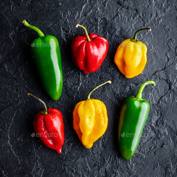 Different colors hot peppers on black background Stock Photo by ivankmit