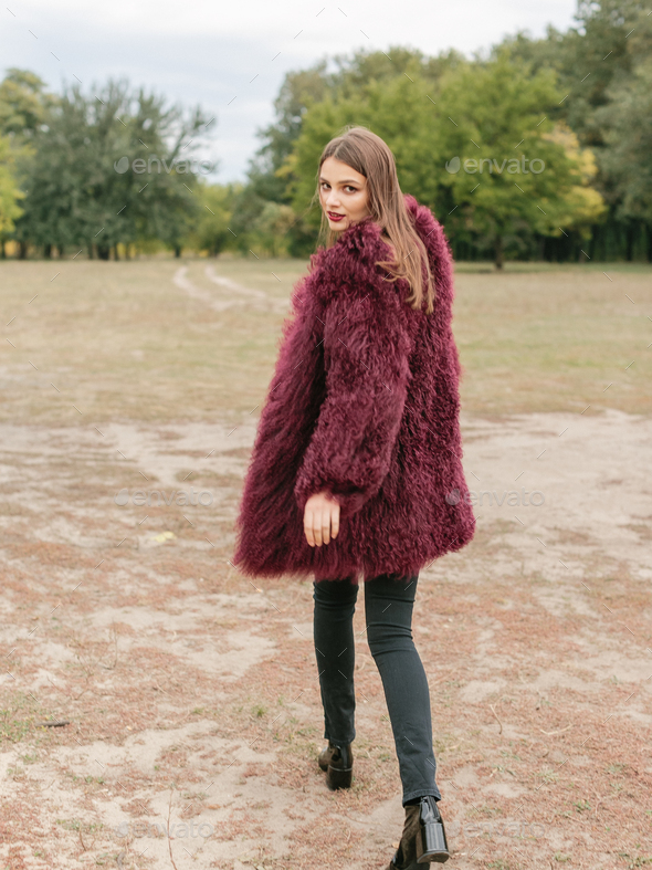 Female with brunette hair and makeup posing in marsala lama fur coat at ...