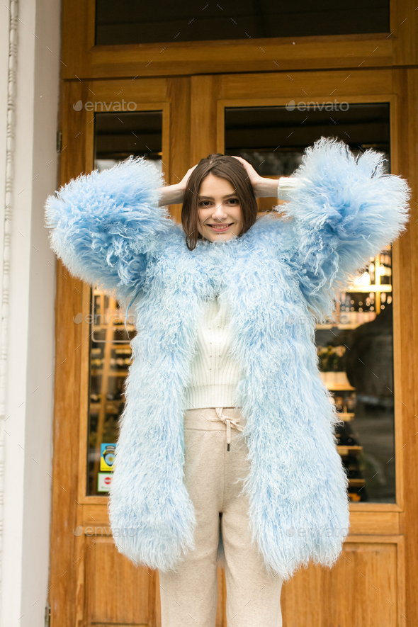 Young smiling women friends posing in pink and blue lama fur coat Stock ...