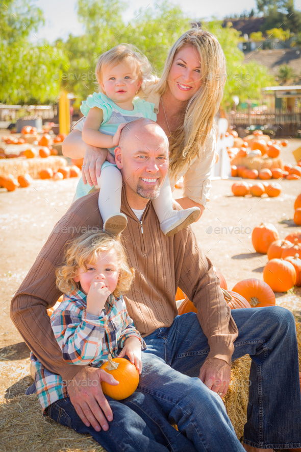 Adorable Young Family Enjoys a Day at the Pumpkin Patch. Stock Photo by ...