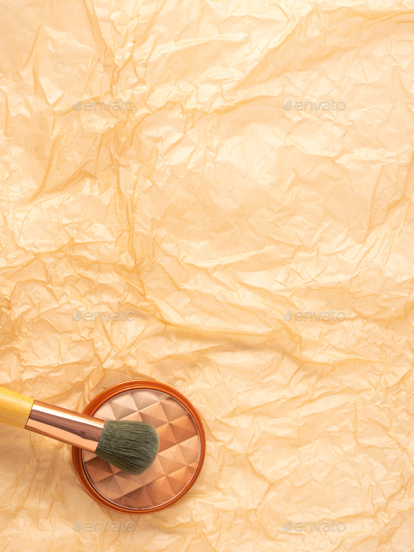 Compact multi color face powder on crumpled beige textured background ...