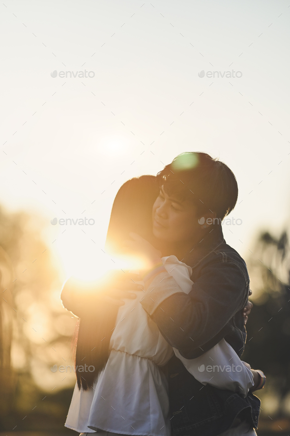 Portrait of LGBT couples while hugging with blur sunlight and tree ...