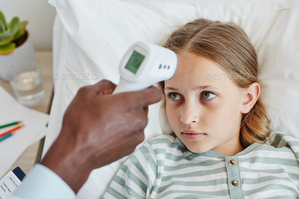 Doctor Using Contactless Thermometer Stock Photo by seventyfourimages