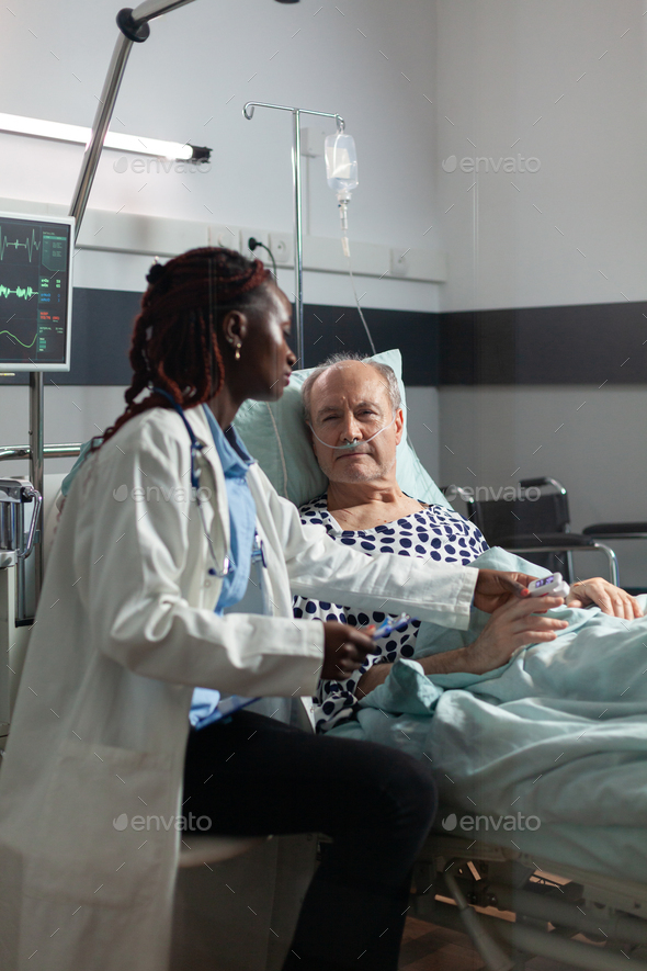 Unwell senior patient laying in bed breathing through oxygen test tube ...