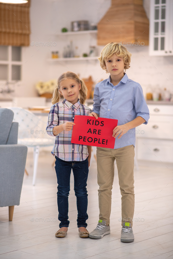 Kids holding red sign, demanding their rights Stock Photo by Zinkevych_D