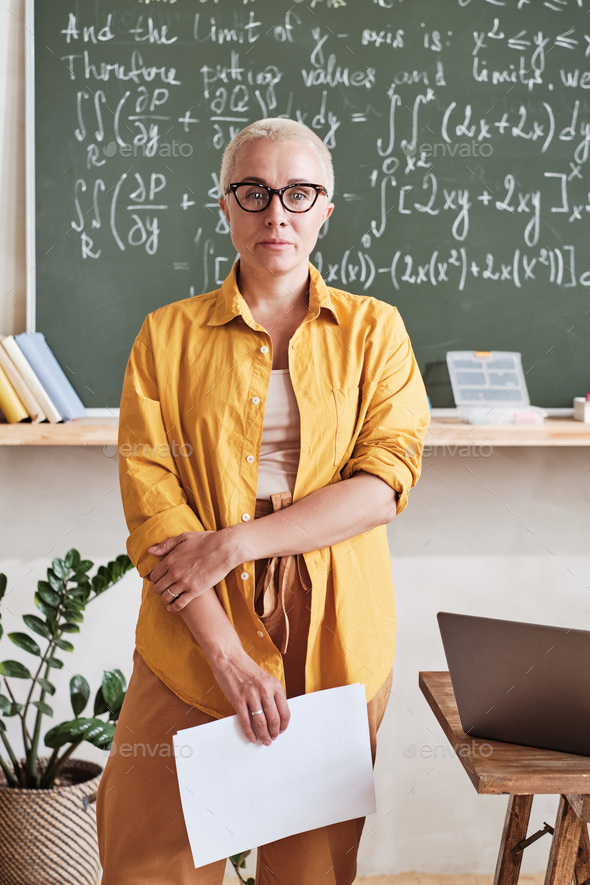 Teacher standing in the classroom at school Stock Photo by AnnaStills