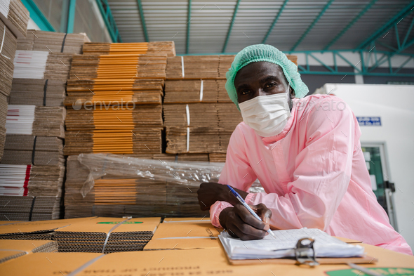 African American man distribution a box package in shipping factory ...