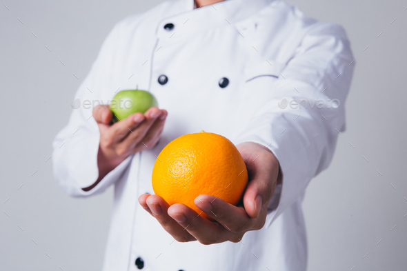 Chef choosing between ingredients of two fruits, choice and dilemma ...