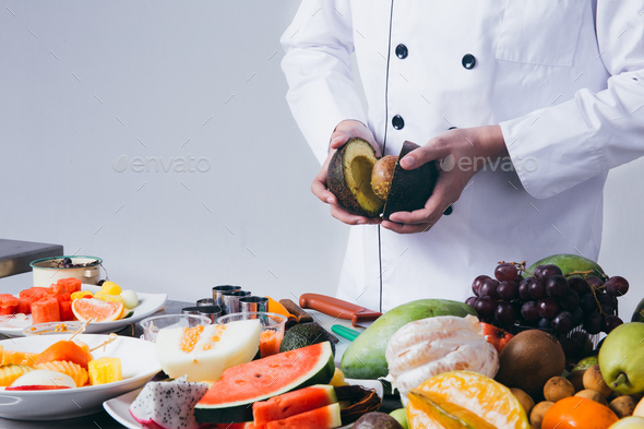 Chef preparing fruits for fruit salad over white background Stock Photo ...