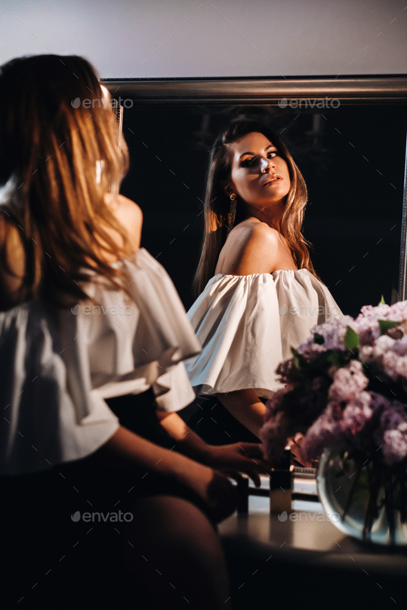Beautiful girl in the mirror reflection at home. Girl before the ...