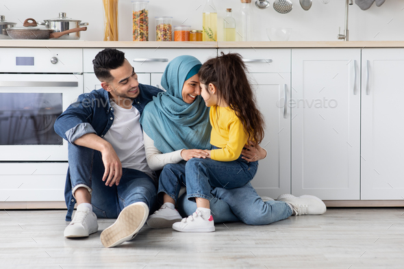 Happy Islamic Parents Bonding With Their Little Daughter In Kitchen ...