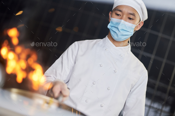 Experienced cook making stir-fry with flames in wok Stock Photo by ...
