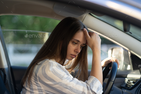 Sad young girl suffer stressed drive car. Unhappy female driver think ...