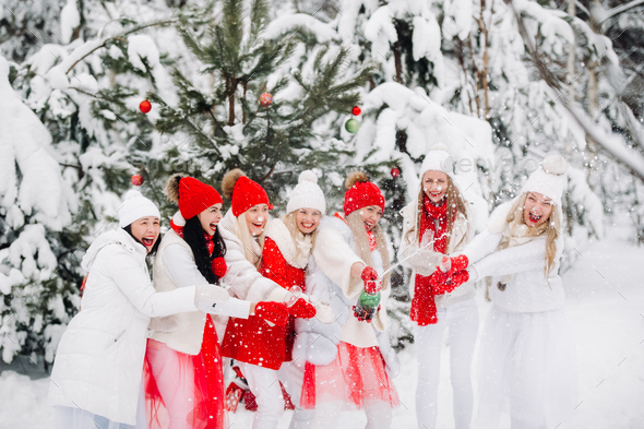 A large group of girls with glasses of champagne in their hands stands ...