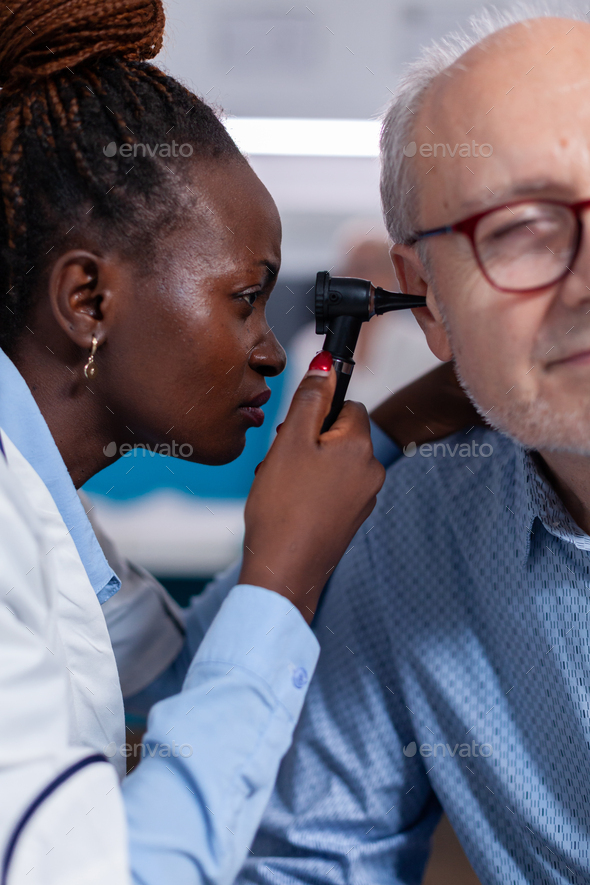 Close up of black doctor using otoscope for ear checkup Stock Photo by ...