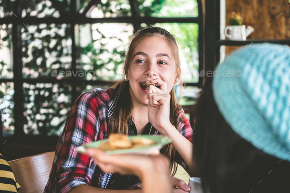 Beautiful young girl eating snack with her friends at home. Stock Photo ...