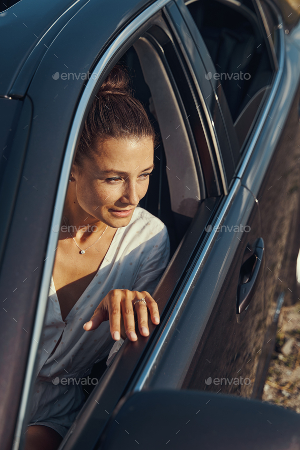 Female looking through the open car window Stock Photo by Iakobchuk