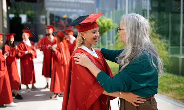University student with senior professor celebrating outdoors ...