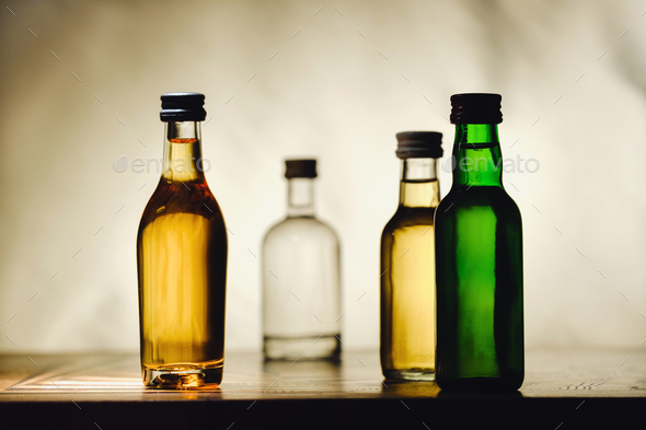 different alcohol bottles are on the table on a light background Stock ...