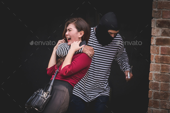 Thief threatening with knife, young woman scared and screaming while ...