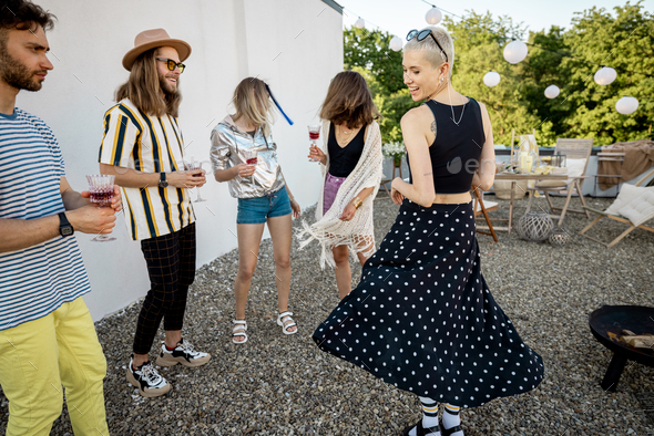 Stylish friends dancing at party outdoors Stock Photo by RossHelen