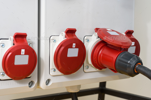 Industrial sockets and plug on distribution board Stock Photo by molenira