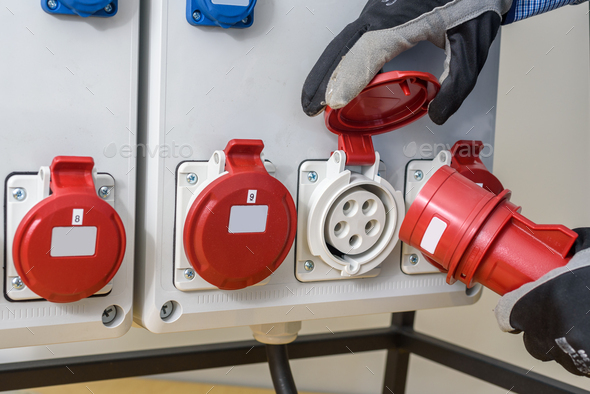Industrial sockets and plug on distribution board Stock Photo by molenira