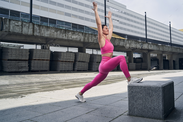 Athlete putting right leg on stone and lifting arms Stock Photo by ...