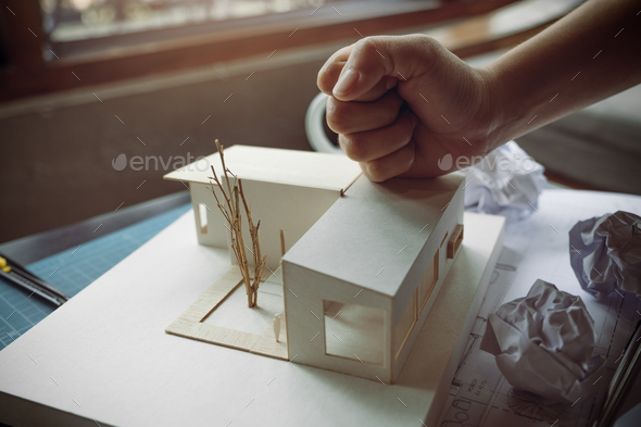 an angry architects try to destroy an architecture model on the table ...