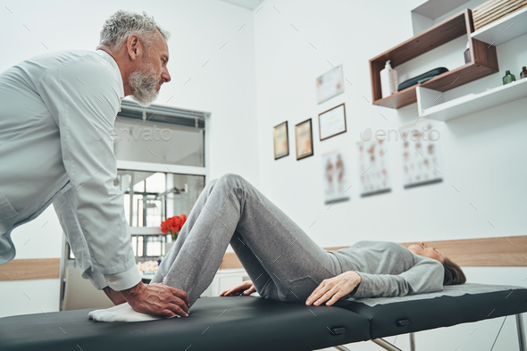 Qualified doctor conducting a manual muscle strength test Stock Photo ...
