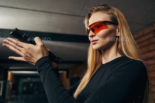 Serious concentrated beautiful lady reloading her handgun Stock Photo ...
