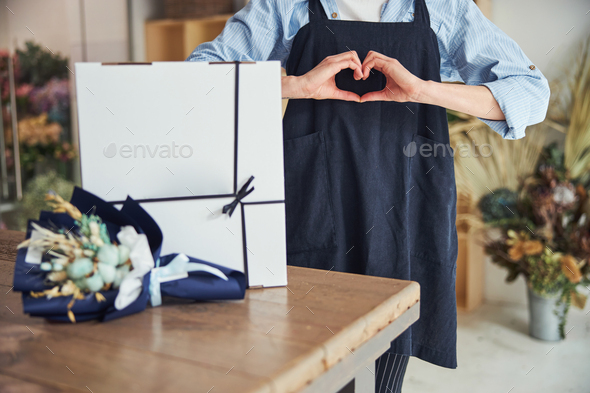 Floral boutique worker showing a heart shape hand gesture Stock Photo ...