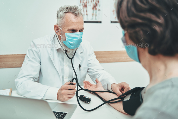 Serious doctor performing a medical examination of a woman Stock Photo ...