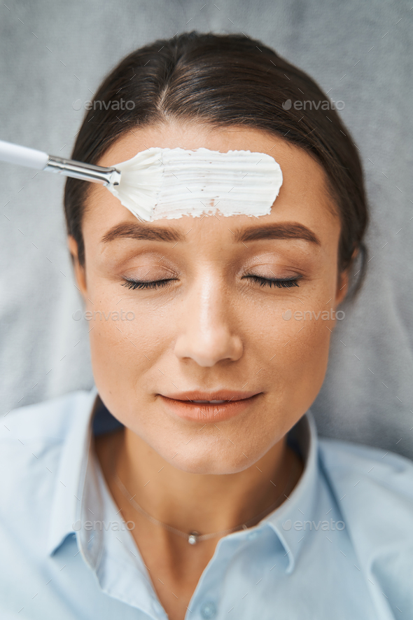 Dermatologist applying a beauty product on her patient face Stock Photo ...