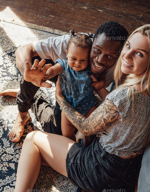 Shot of young mixed race family in bedroom in daytime Stock Photo by ...