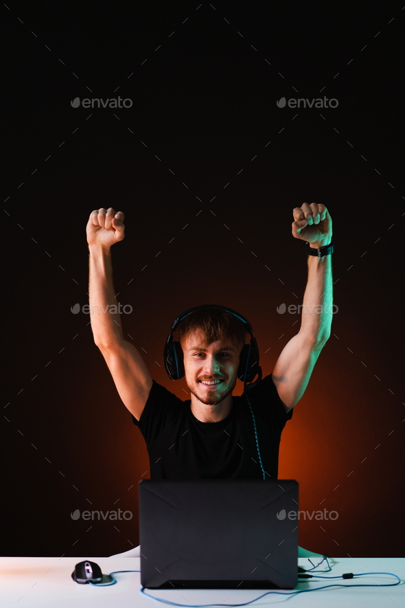 Guy gamer winner with headset playing video games on his personal ...