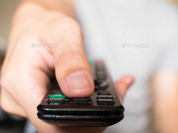 Close up of man pressing a button on remote control (shallow depth of ...