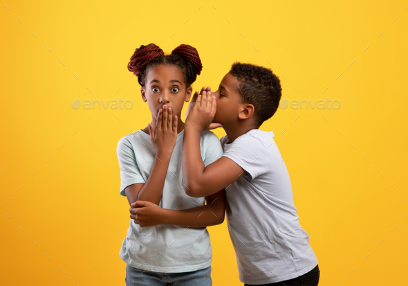 Black boy brother sharing secrets with his older sister Stock Photo by ...