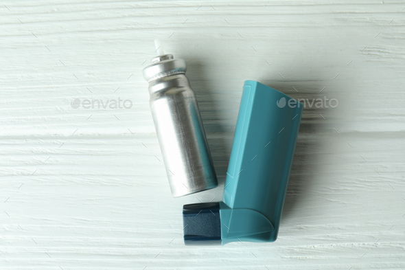 Blue asthma inhaler on white wooden table Stock Photo by AtlasComposer