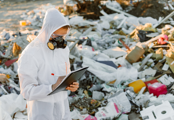 Researcher looking at plastic landfill analyzing environmental ...