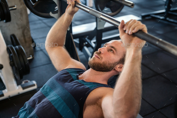Handsome muscular man working out hard at gym Stock Photo by nd3000