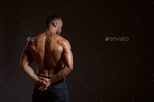Strong male athlete poses in studio, back view Stock Photo by NomadSoul1