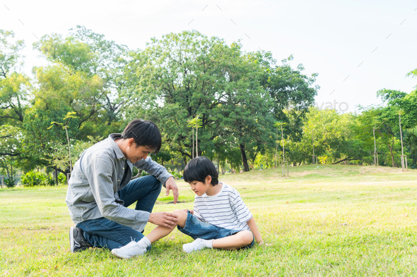 Asian father helping son falling down and get knee injury Stock Photo ...
