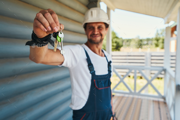 Construction worker handing over keys to house Stock Photo by Iakobchuk