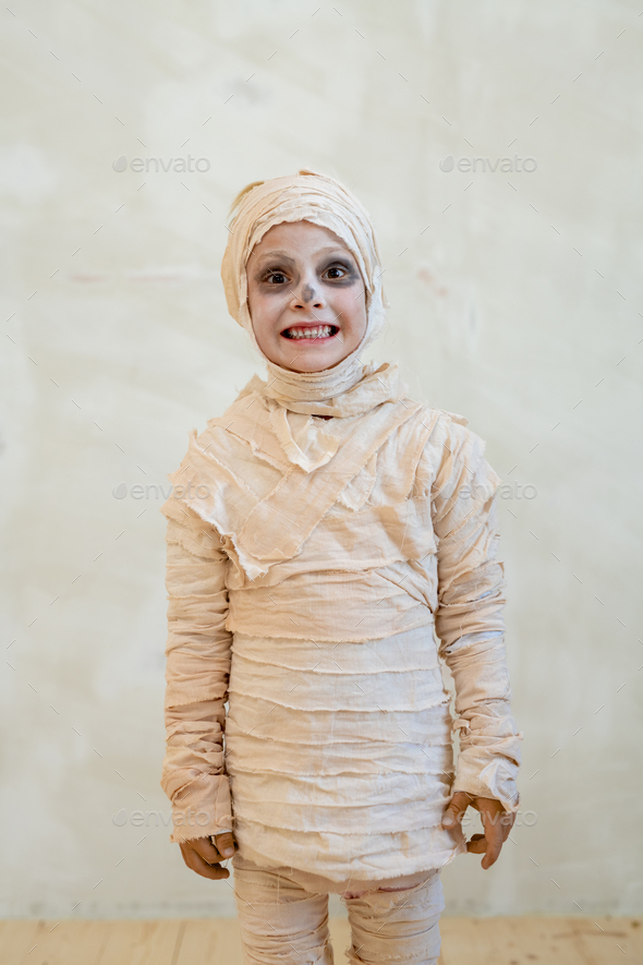 Cute little boy in mummy costume standing against white wall Stock ...