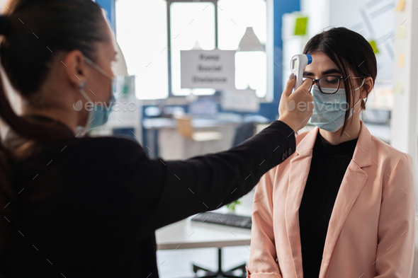 Executive manager measuring temperature using infrared medical ...