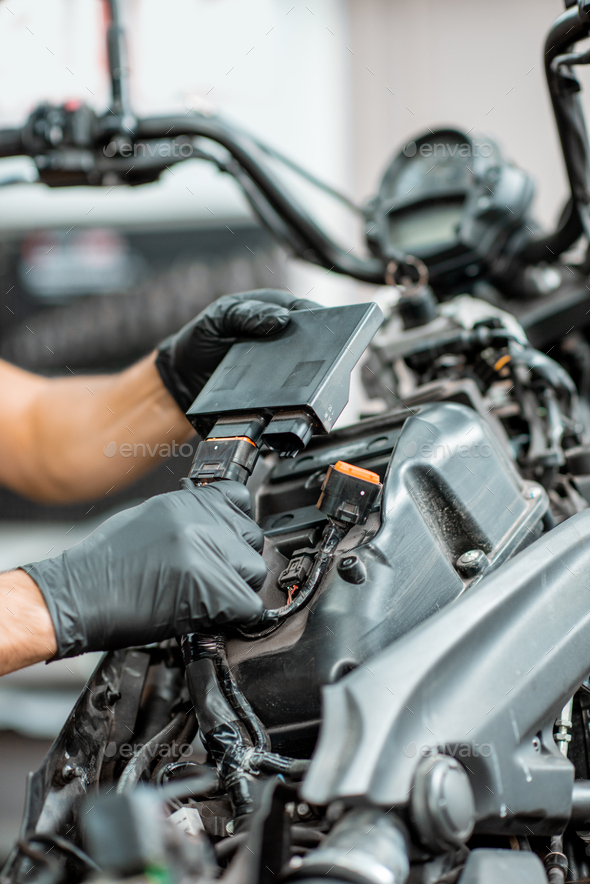 Electrician repairing motorcycle wiring Stock Photo by RossHelen ...