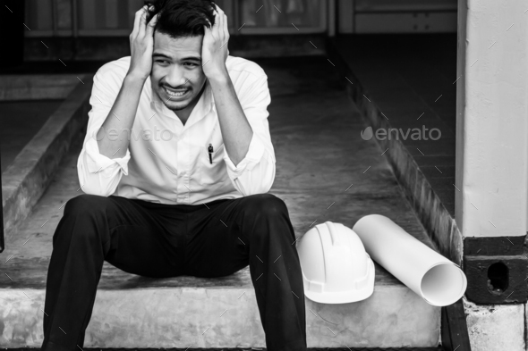 Young asian engineer suffering stress working at construction site ...