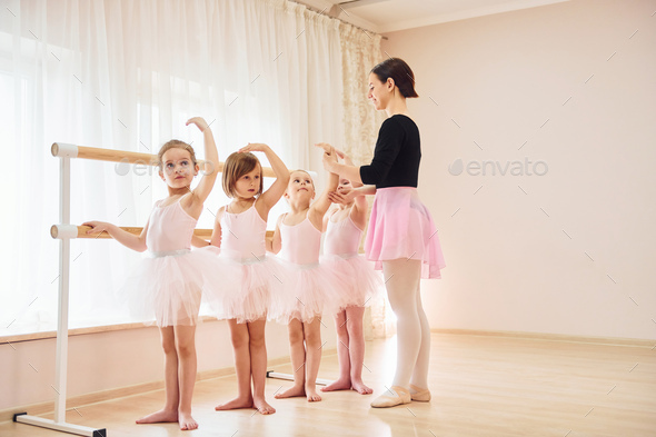 Working with coach. Little ballerinas preparing for performance by ...