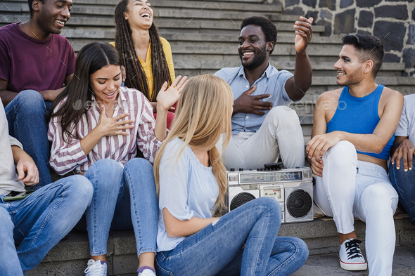 Young diverse people dancing and listening music with boombox stereo ...